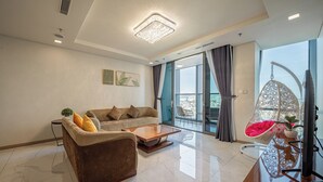 Uma sala de estar moderna com um sofá, mesa de centro e uma cadeira suspensa.