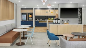 Cozinha moderna com ilha central, eletrodomésticos embutidos e iluminação pendente.
