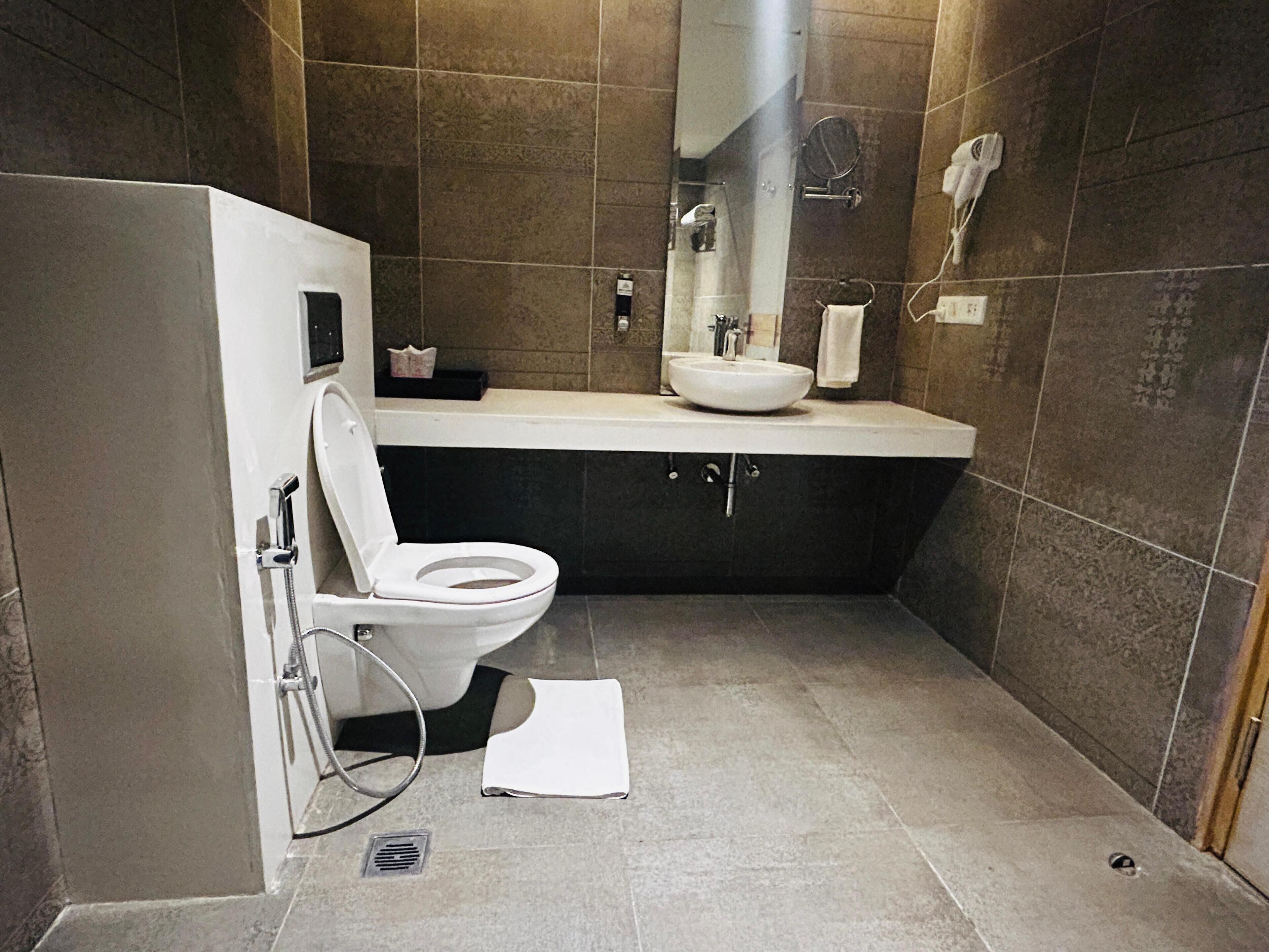 Uma casa de banho moderna com sanita branca, lavatório e espelho.