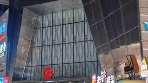 Fachada moderna de edifício com painéis de vidro refletivos e um grande número '2' em destaque.