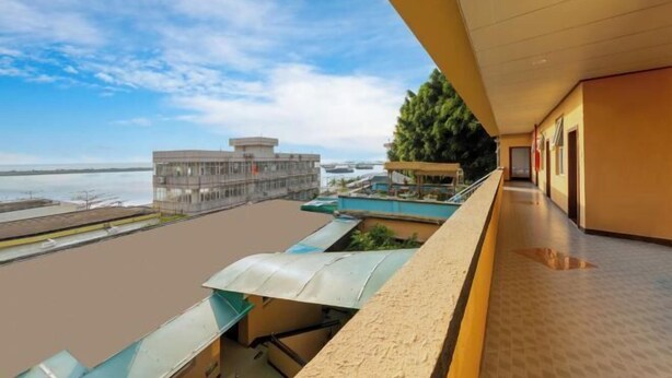 Varanda de hotel com vista para a praia e o oceano.