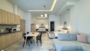 Um apartamento moderno com sala de jantar, sala de estar com sofá e quarto com cama.