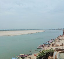 Margem de rio com barcos atracados e pessoas praticando diversas atividades.