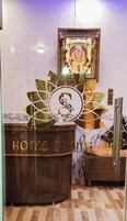 Uma receção com um logótipo, um quadro religioso emoldurado e uma parede de mármore.