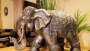 Escultura decorativa de elefante sobre uma superfície de madeira.