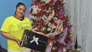 Árvore de Natal decorada com um ursinho de pelúcia e um presente embrulhado.