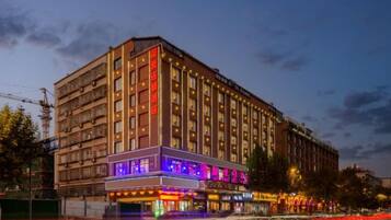 Hotel de vários andares com teatro no nível térreo, apresentando uma grande marquise e sinalização iluminada.