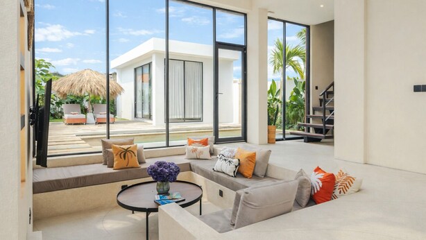 Uma sala de estar moderna com uma janela grande, um sofá, uma mesa de centro e vista para uma piscina e área externa.