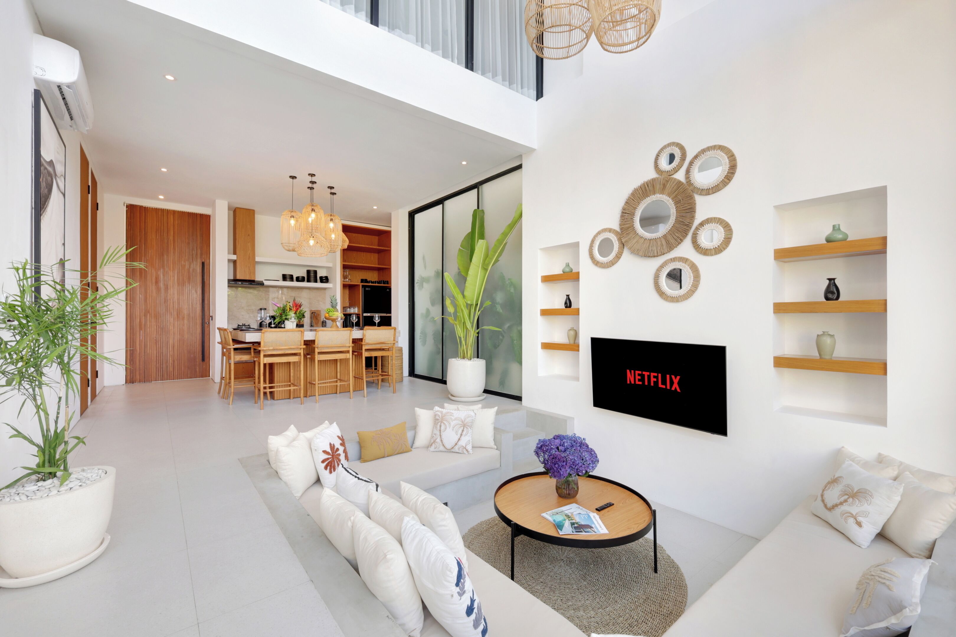 Uma sala de estar moderna com sofá, mesa de centro e televisão fixada na parede.