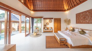 Quarto espaçoso com cama grande, teto de madeira e vista para piscina e área externa.