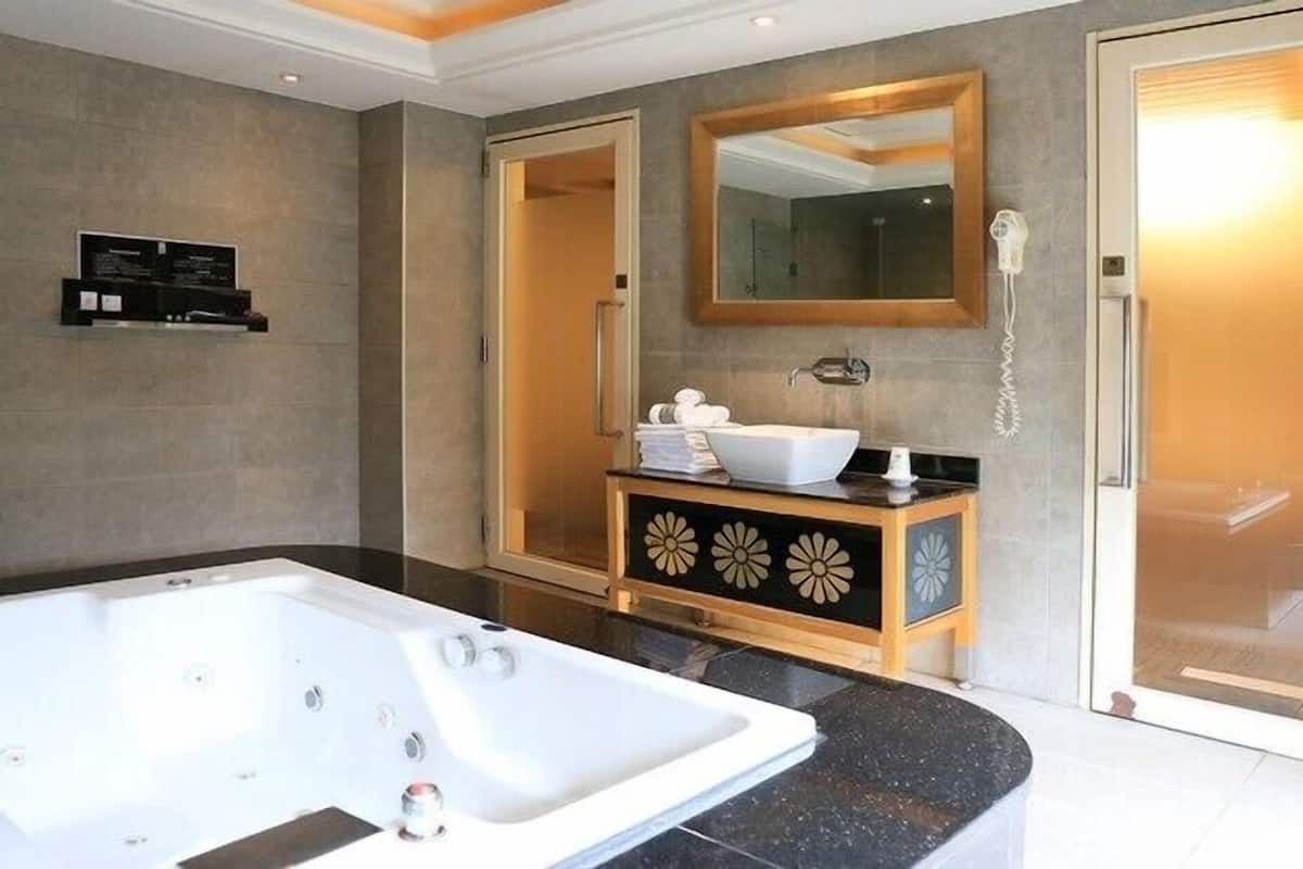 Uma casa de banho moderna com uma banheira grande, uma pia com espelho e uma área de duche.