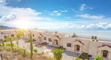 Resort com vários edifícios, áreas externas e vista para o mar.