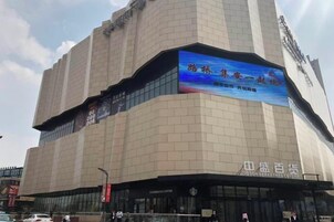 Edifício de vários andares com um grande painel de sinalização digital na lateral.