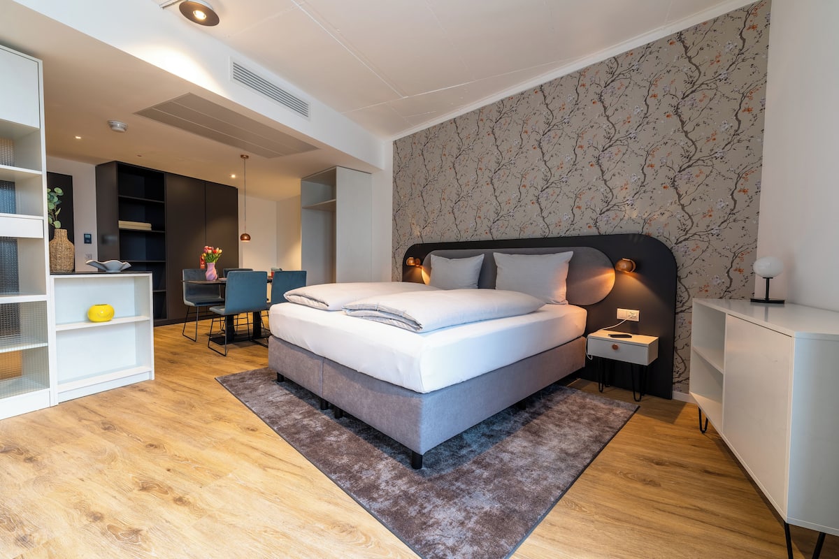 Quarto moderno com uma cama grande, uma escrivaninha e um guarda-roupa.