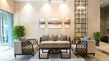 Uma sala de estar moderna com um sofá, duas poltronas, uma mesa de centro e um painel decorativo.