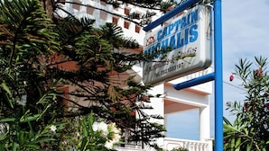 A building with a sign reading "Captain Ellis Studios" and a contact number.