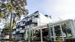 Um edifício moderno de vários andares com área de estar ao ar livre envidraçada.