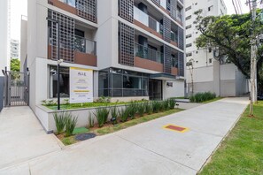 Um edifício moderno com uma placa anunciando 'ALLE Studios' e 'E coworking'.