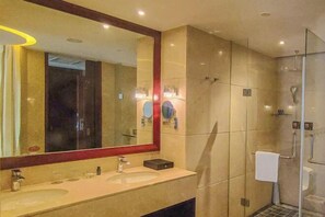 Uma casa de banho moderna com um espelho grande, duas pias, zona de duche e um porta-toalhas.