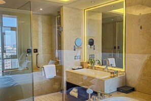 Uma casa de banho moderna com chuveiro envidraçado, um espelho grande e uma banheira.