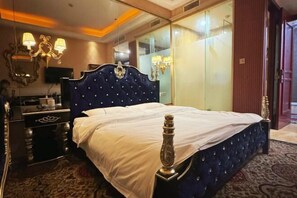 Quarto com uma cama grande, cômoda, espelho e televisão.