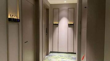 Corredor de hotel com portas identificadas como 'M203' e 'M204'.
