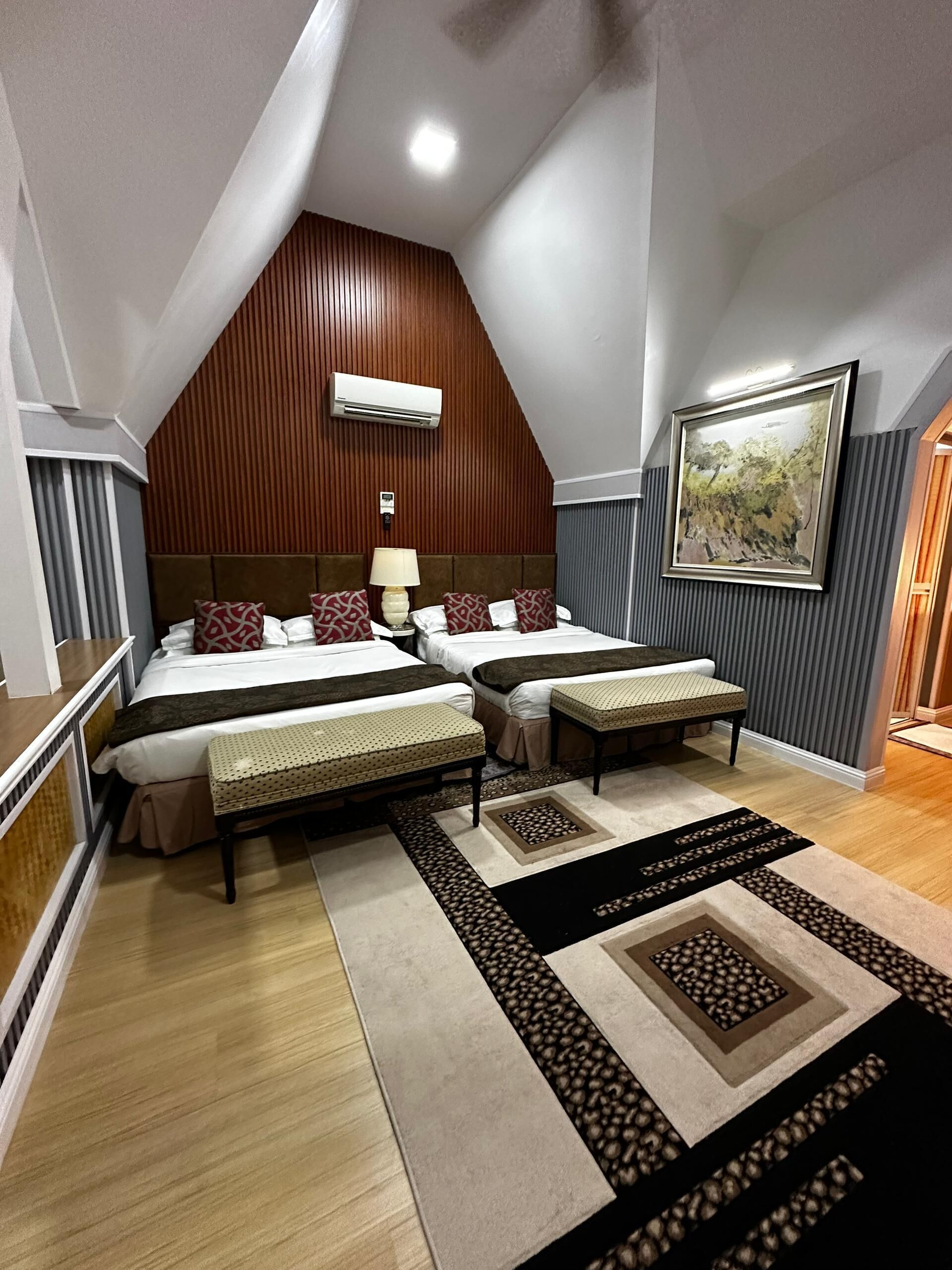 Quarto de hotel com duas camas, um quadro grande na parede e design moderno.