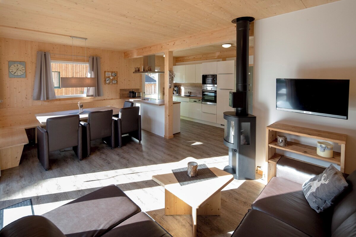 Interior acolhedor de uma cabana com área de jantar, cozinha e sala de estar.