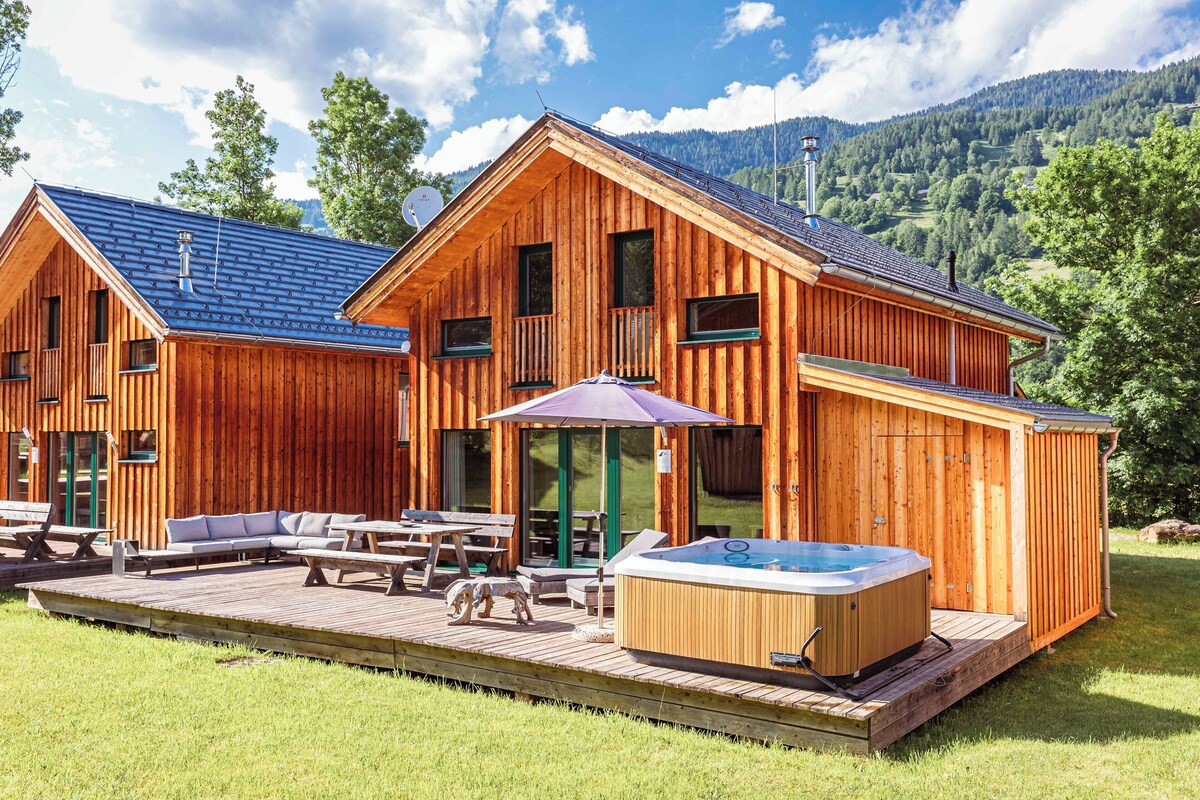 Uma cabana de madeira com hidromassagem, área de estar externa e um deck.