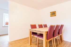 Uma sala de jantar com uma mesa de madeira e seis cadeiras.