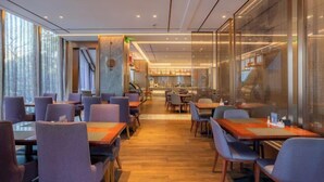 Restaurante moderno com mesas e cadeiras de madeira, janelas amplas e divisória de vidro.