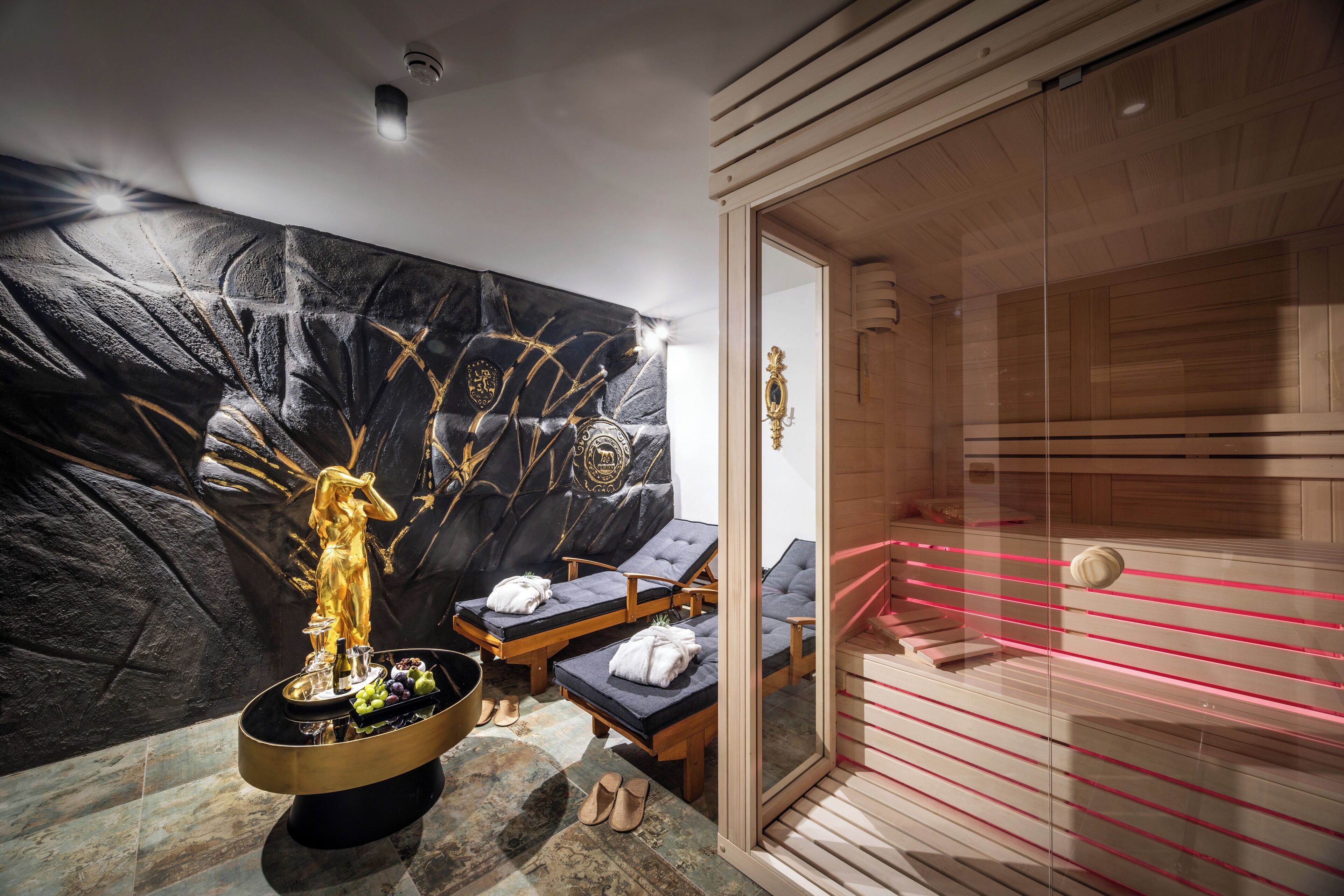Uma sala de spa com mesa de massagem, uma estátua decorativa e sauna.