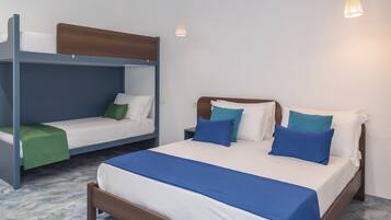 Quarto com uma cama de solteiro, uma beliche e uma mesa de cabeceira.
