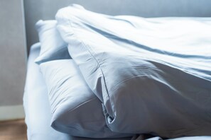 Uma cama bem arrumada com lençóis brancos.