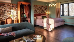 Quarto moderno com uma cama grande, um sofá, uma mesa de centro e parede decorada com fotografias.