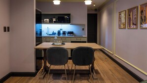 Cozinha moderna com área de jantar, com luminárias pendentes, micro-ondas e máquina de café.