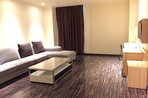 Uma sala de estar moderna com sofá, mesa de centro e aparador para TV.
