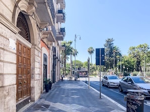 Vista da rua com um edifício com uma grande porta de madeira e uma placa que diz 'PRESIDIUM'.