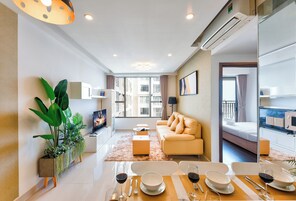 Uma sala de estar moderna com sofá, mesa de jantar e plantas em vasos.
