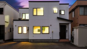 Um edifício moderno de vários andares, com janelas iluminadas e telhado plano.