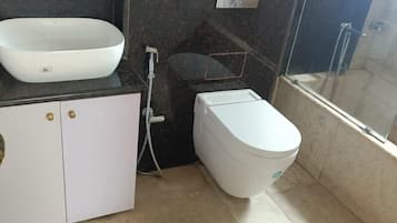 Chuveiro, toalhas de banho, sabonete, papel higiênico