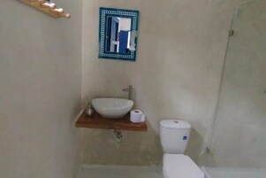 Um banheiro pequeno com vaso sanitário branco, pia branca e espelho com moldura azul.