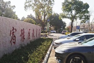 Uma área de estacionamento com um muro de pedra e uma placa com caracteres chineses.
