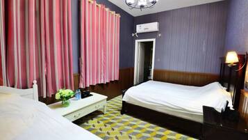 Quarto de hotel com cama, mesa de cabeceira e escrivaninha com luminária.