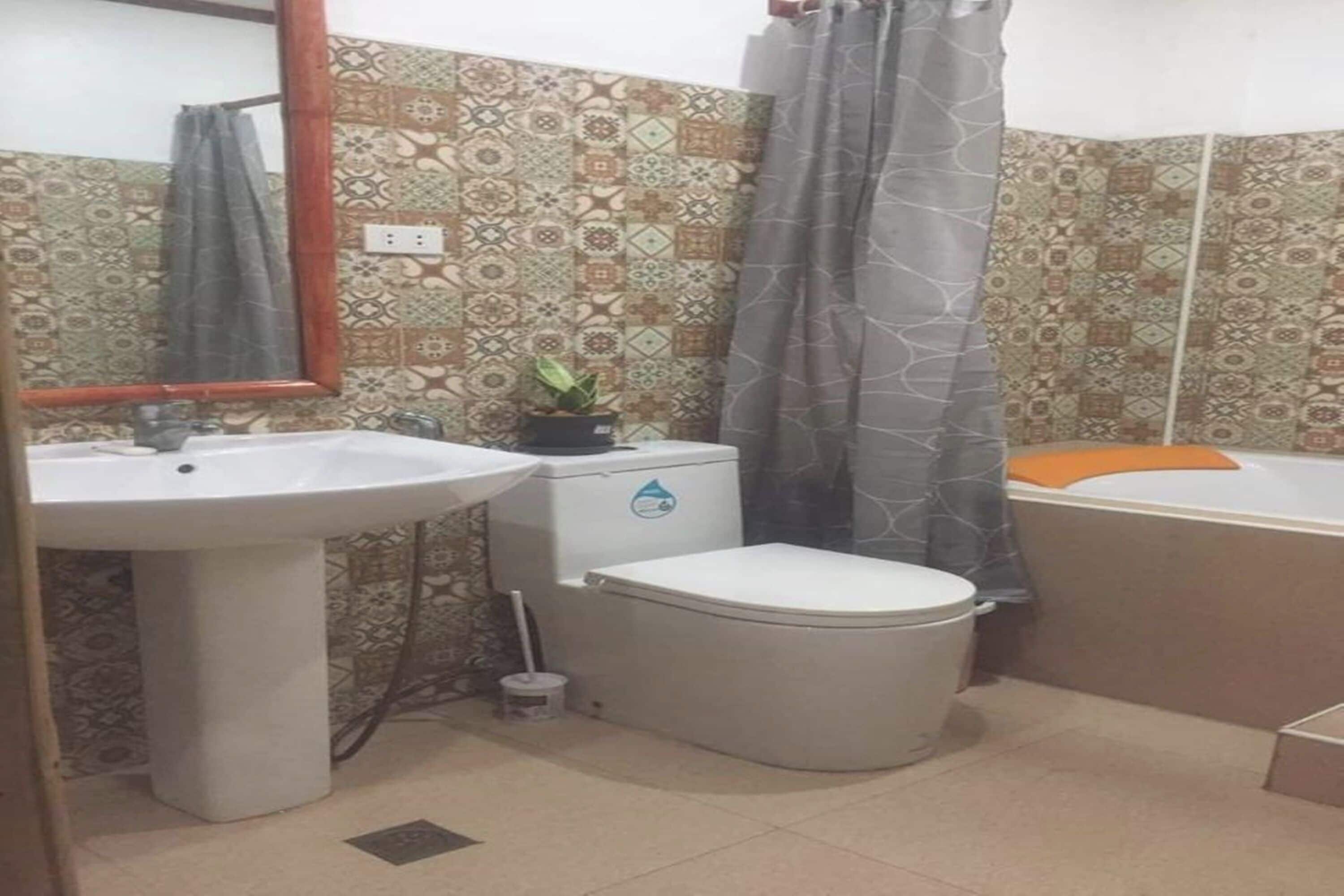 Uma casa de banho com pia, sanita e banheira.