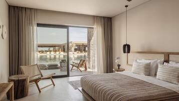 Quarto de hotel com uma cama grande, vista para piscina e área externa, e um ventilador de teto.