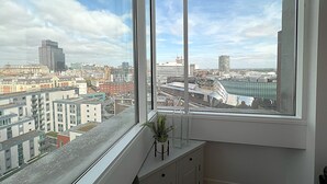 Apartamento alto com uma janela grande que oferece vista para a cidade.