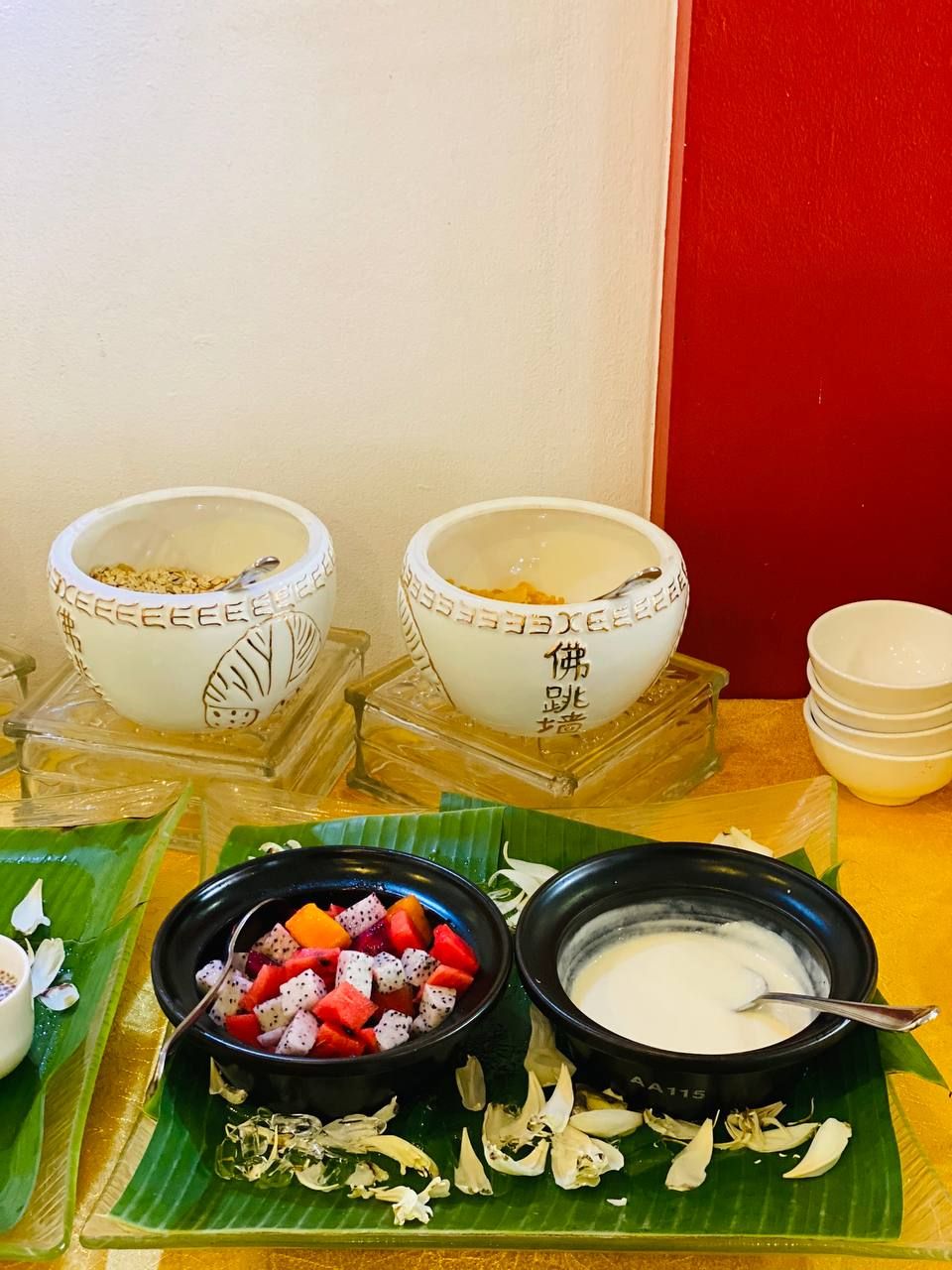 Uma mesa com diversos alimentos, incluindo tigelas de arroz, uma salada de frutas e uma sopa.