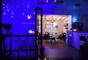 Uma sala de jantar moderna com divisória de vidro, um candelabro e um relógio de parede.