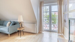Uma sala moderna com sofá, luminária e vista para uma varanda externa.